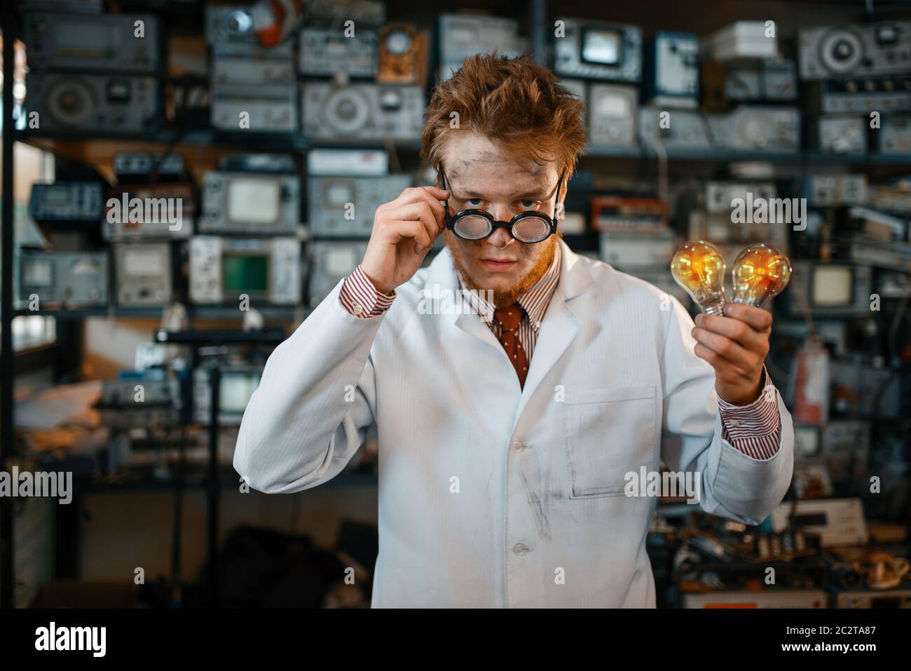 Strange engineer holds electric lamp in laboratory. Electrical testing ...