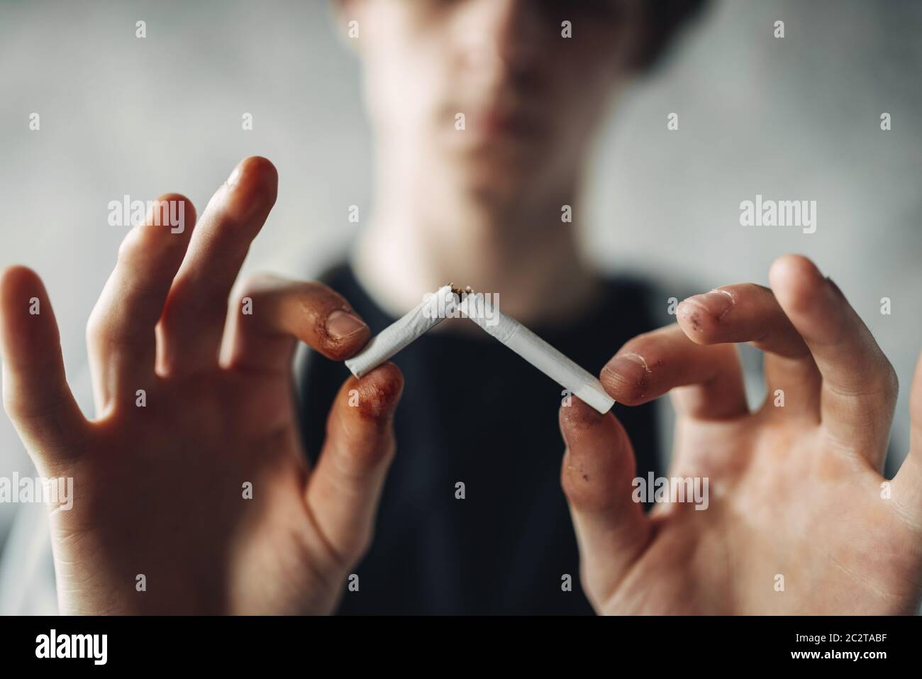 Addicted male person breaks a cigarette, blur background. Smoking ...
