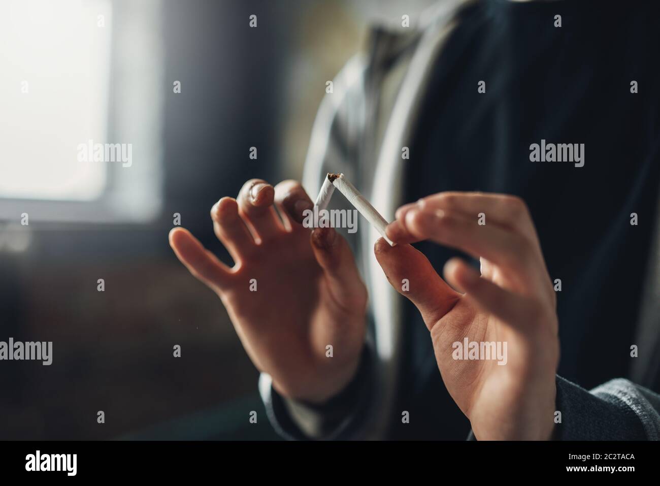 Addicted male person breaks a cigarette, blur background. Smoking ...