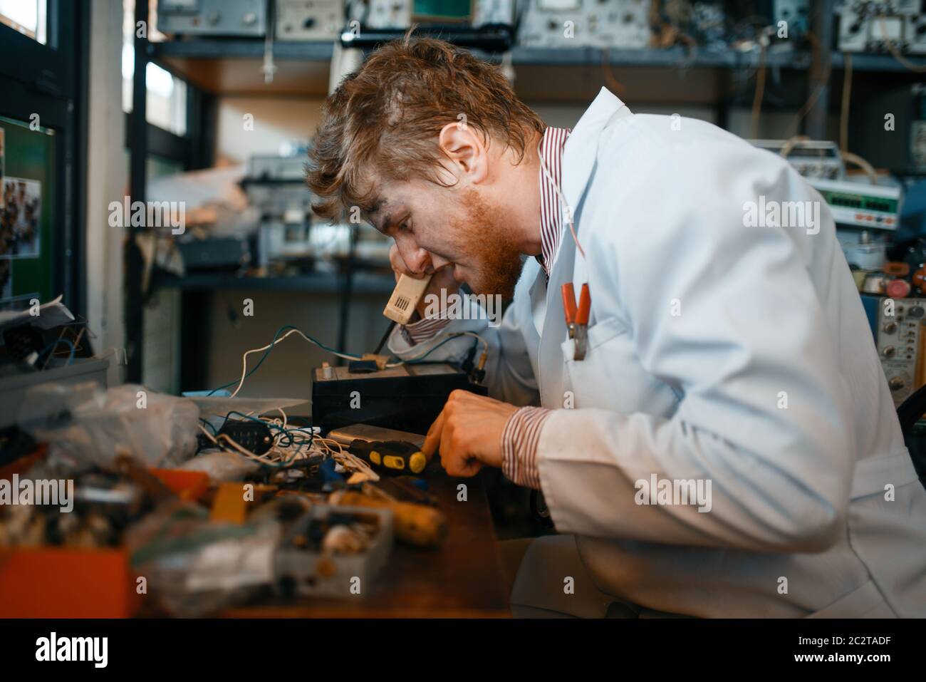 Strange scientist works with soldering iron, test in laboratory ...