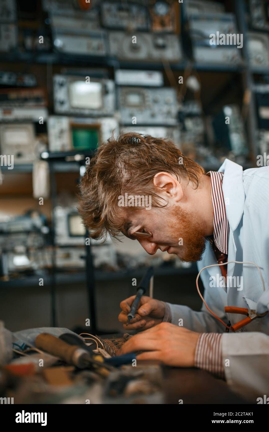 Strange scientist works with soldering iron, test in laboratory ...