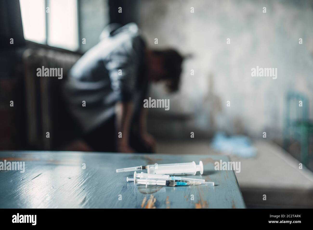 Syringe and spoon for dose preparing on the table, drug addict catches ...