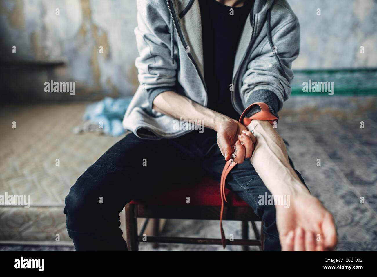 Male person with a syringe doing an injection dose in the arm. Narcotic ...