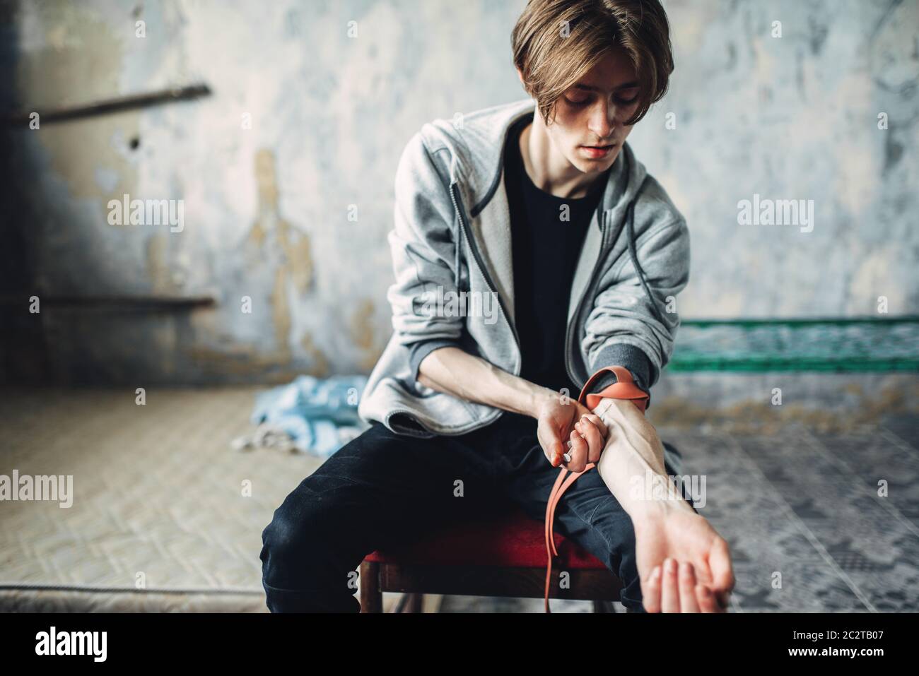 Male junky with a syringe doing an injection dose in the arm. Narcotic ...