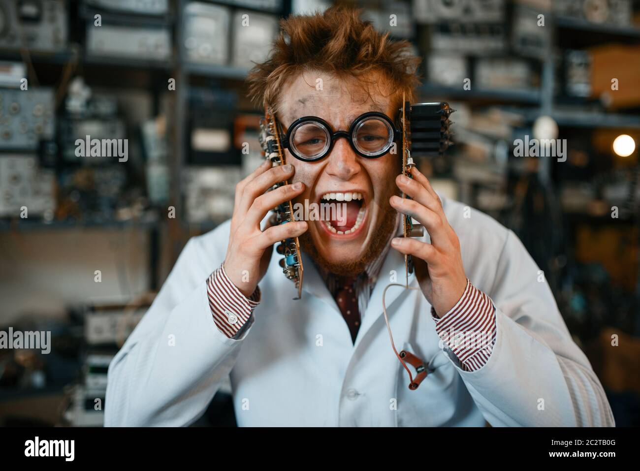 Strange engineer holds electronic chips at his face in laboratory ...