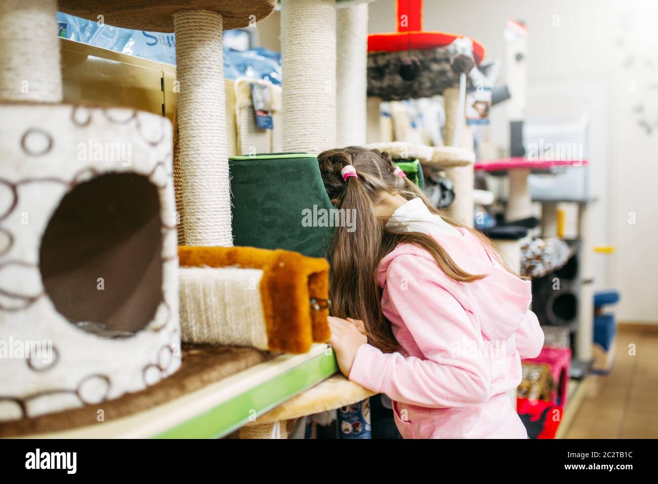 Little girl chooses supplies for cat in petshop. Family buying ...