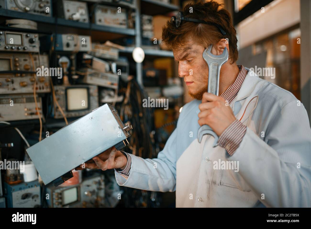 Strange scientist with electric device and huge wrench, test in ...