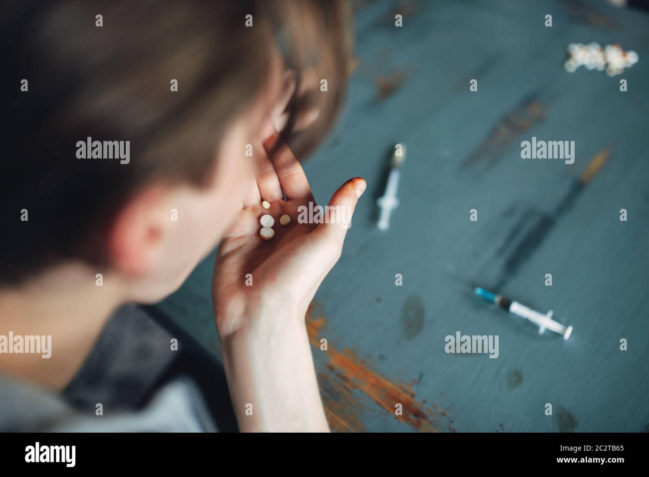 Male junkie accept grugs, syringe on the table on background. Addiction ...