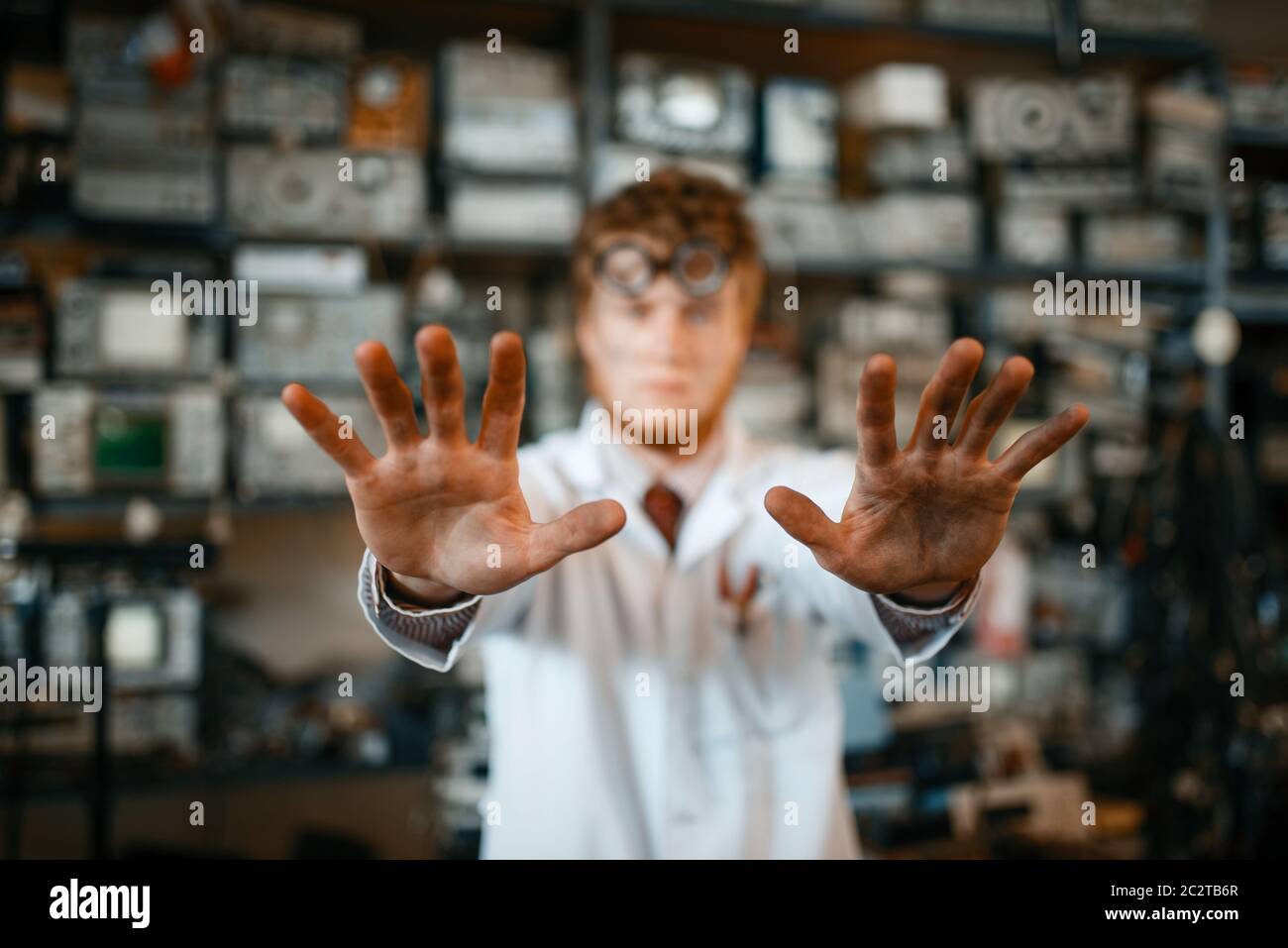 Strange scientist showing scorched hands in laboratory. Electrical ...