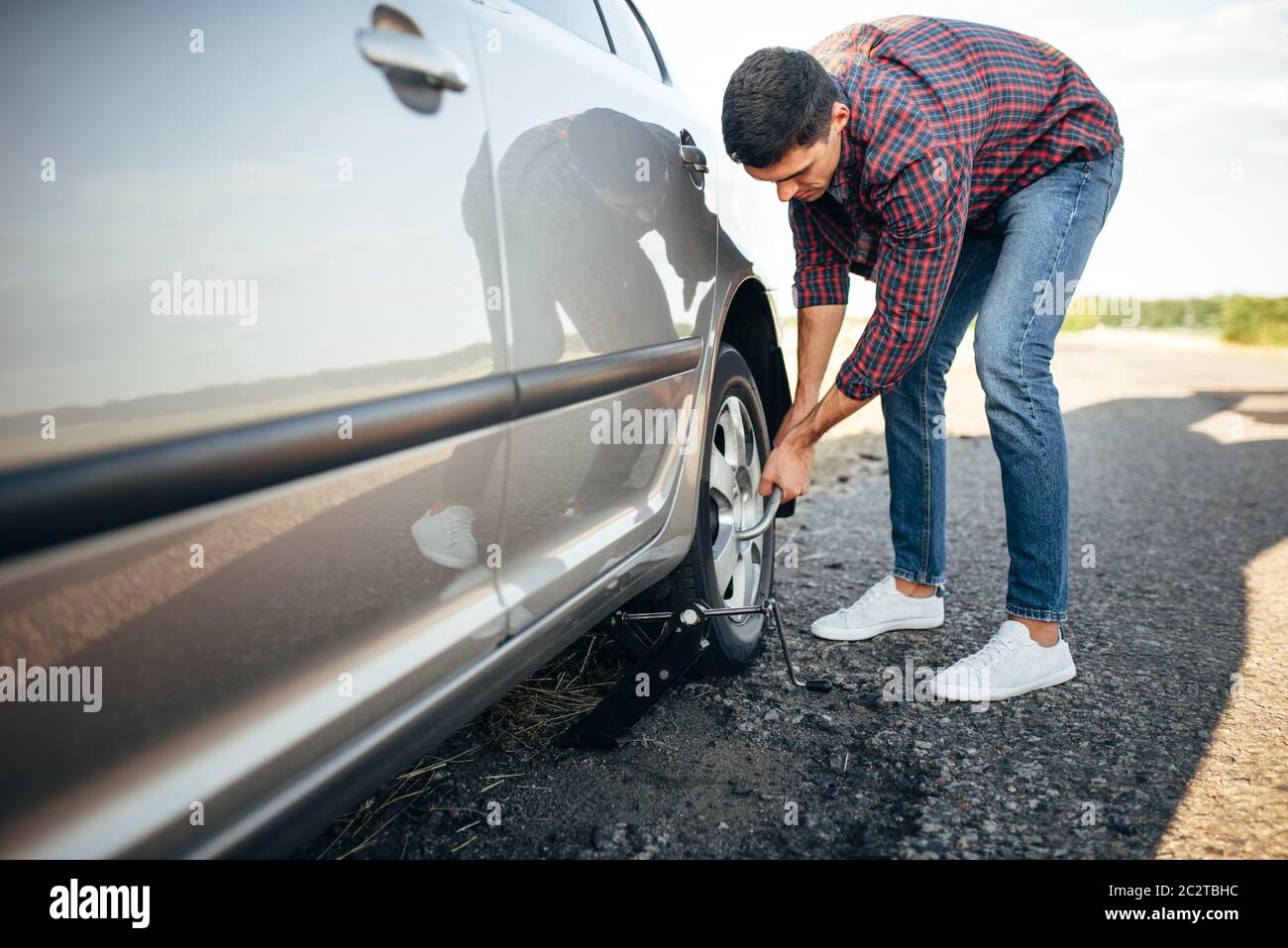 Male person hands with wheel wrench, broken car. Vehicle with puncture ...