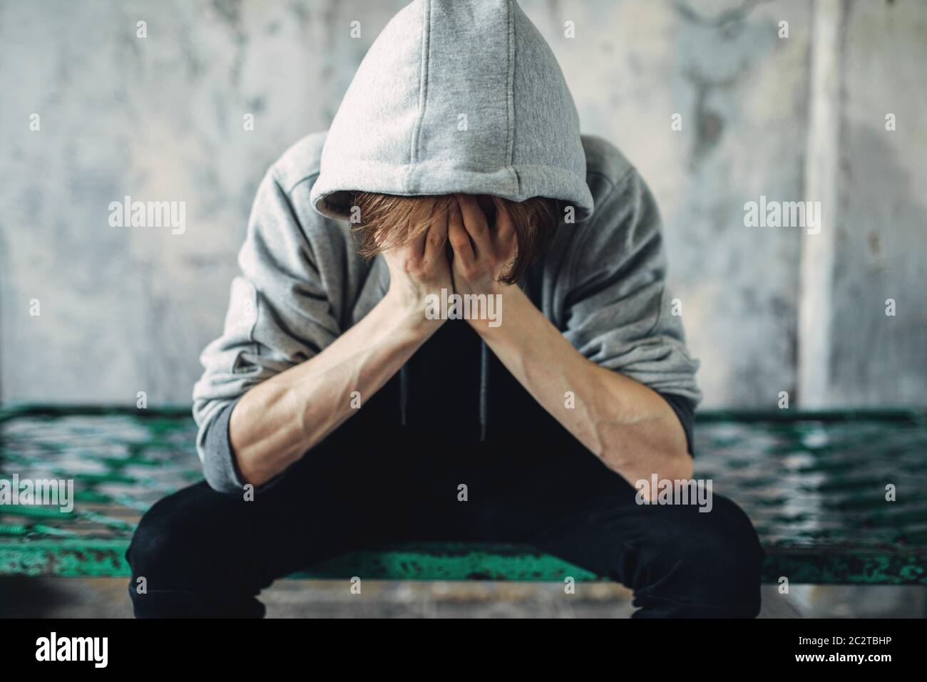 Depressed junkie sitting on the bed, withdrawal symptom. Narcotic ...