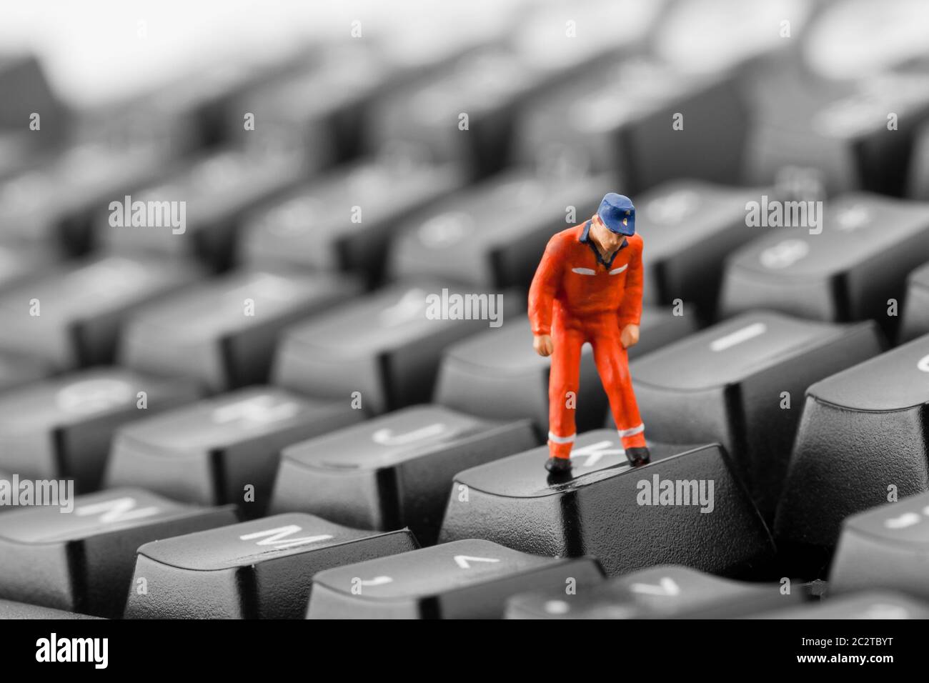 Figurine of worker looking into pit in computer keyboard Stock Photo ...