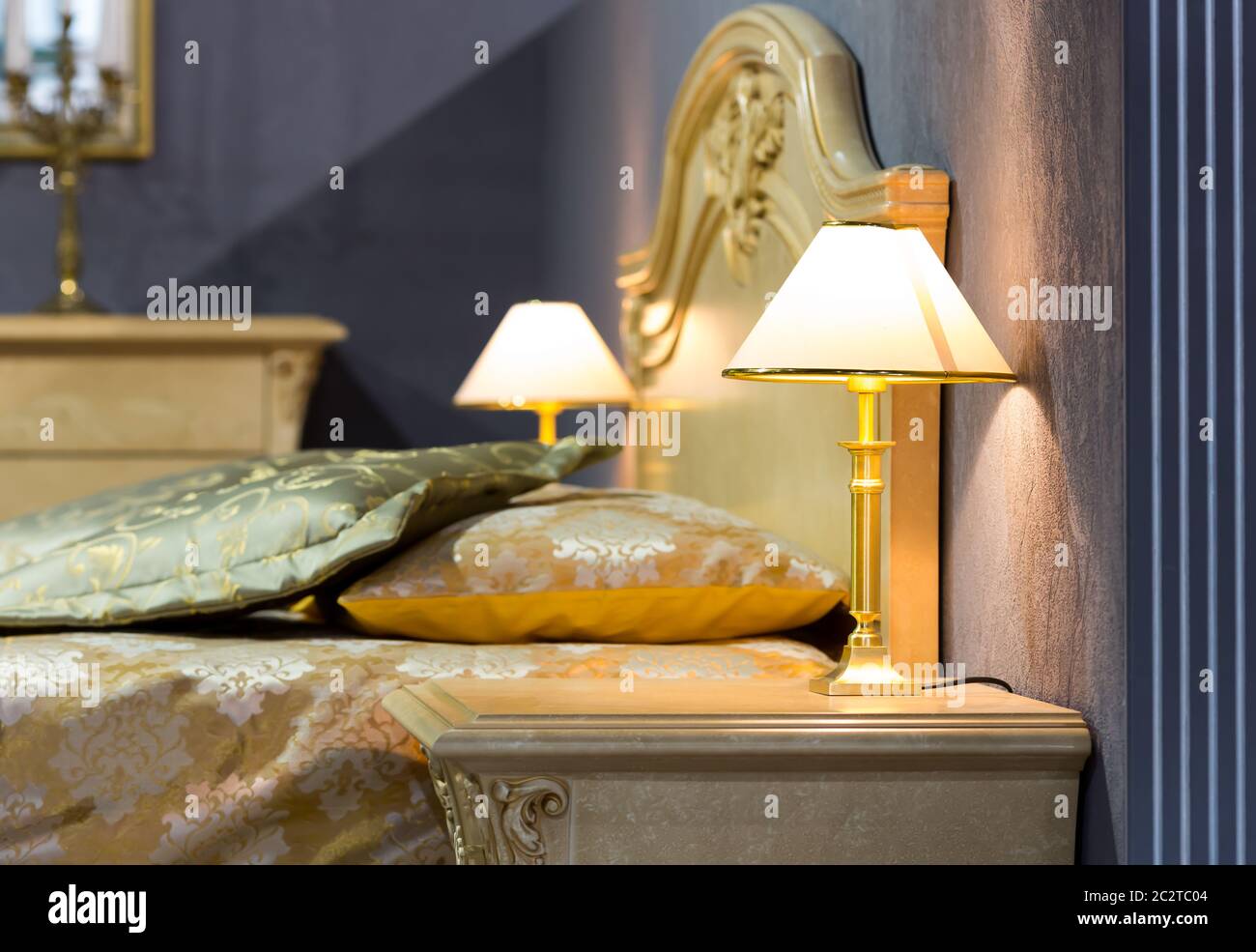 Nice golden bed in typical contemporary setting Stock Photo - Alamy
