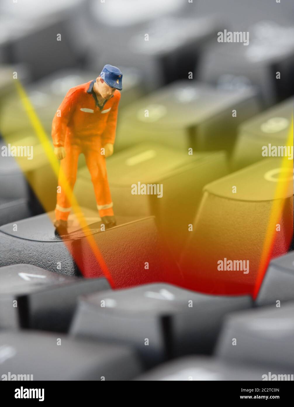 Figurine of worker looking into pit in computer keyboard Stock Photo ...