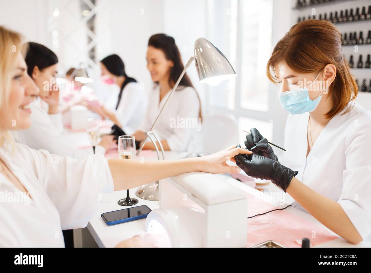Group of women relax on manicure procedure in beauty salon ...