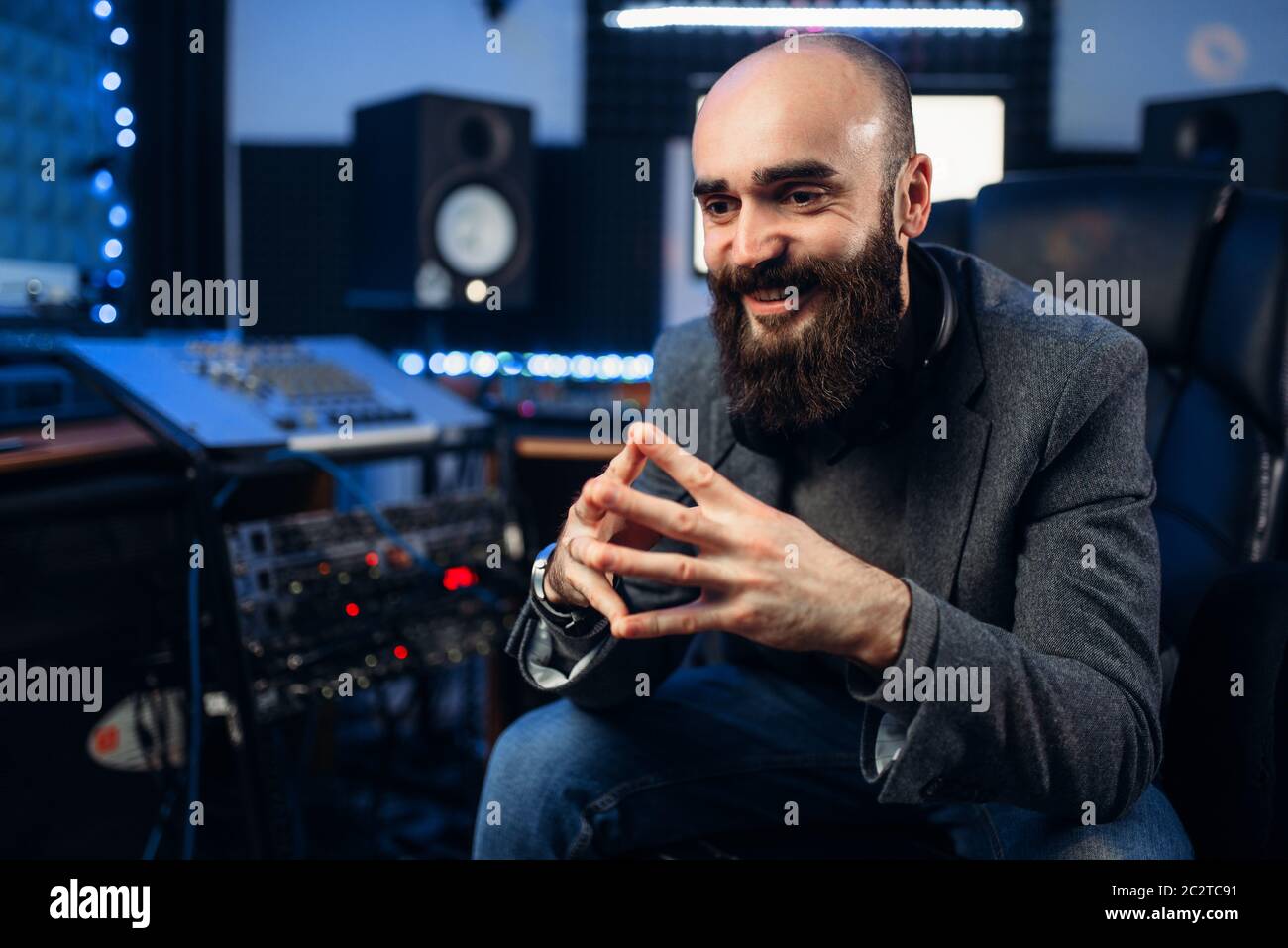 Sound producer in headphones listens composition of female singer in ...