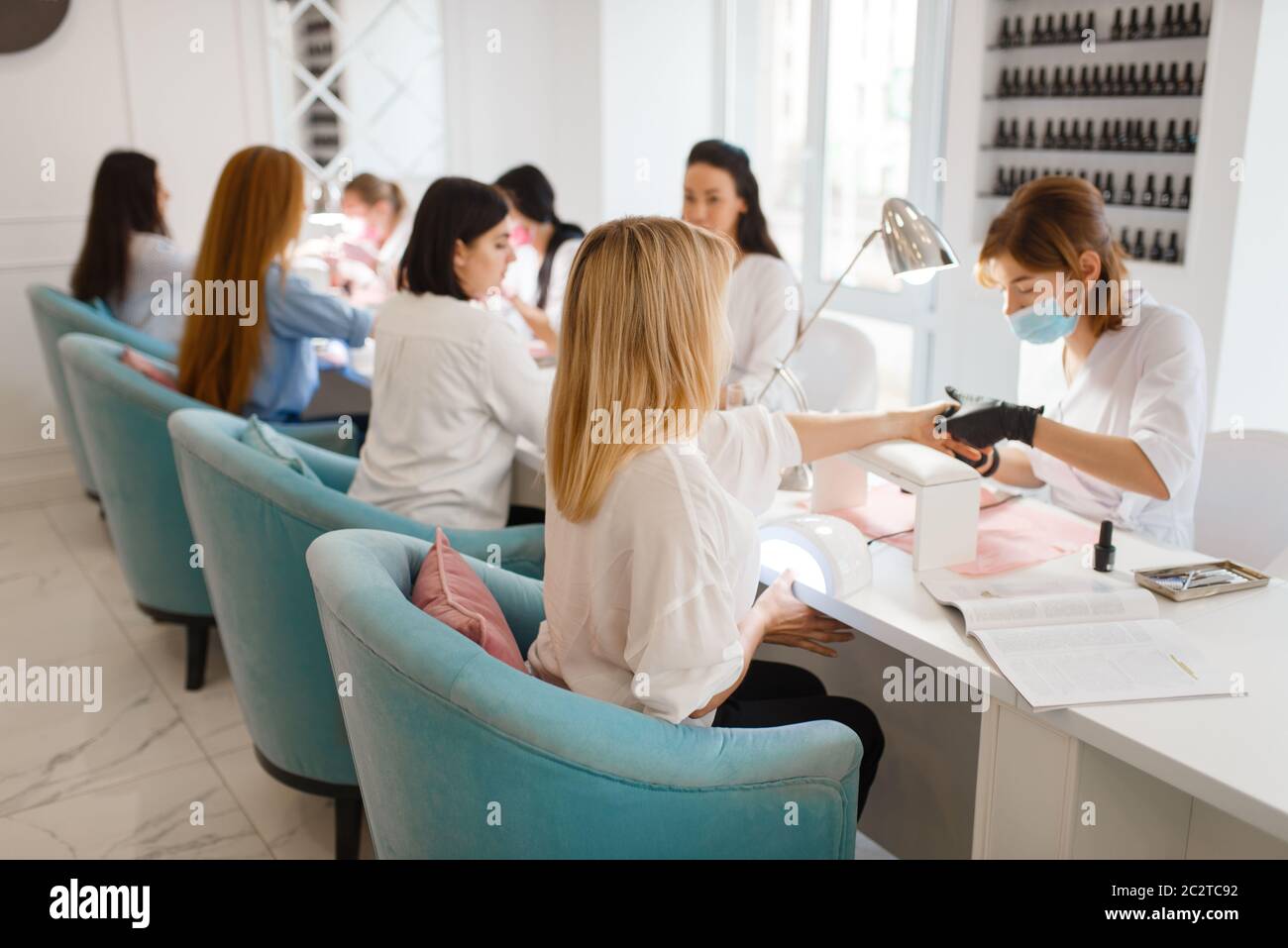 Group of girlfriends relax on manicure procedure in beauty salon ...