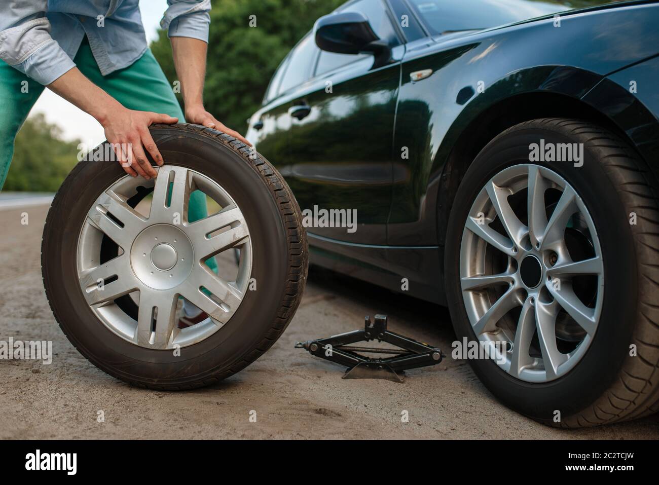 Car breakdown, man puts the spare tire. Broken automobile or problem ...