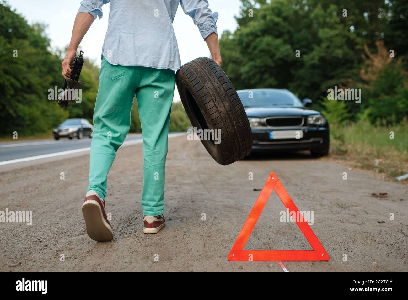 Car breakdown, man puts the spare tyre. Broken automobile or problem ...