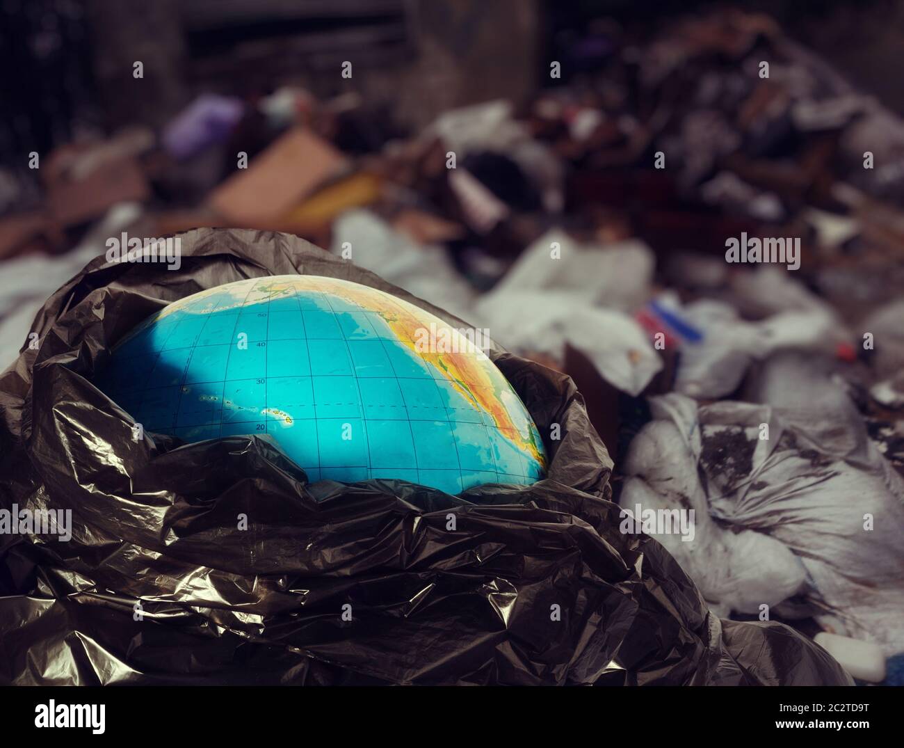 Earth contamination concept. Earth globe in trash Stock Photo - Alamy