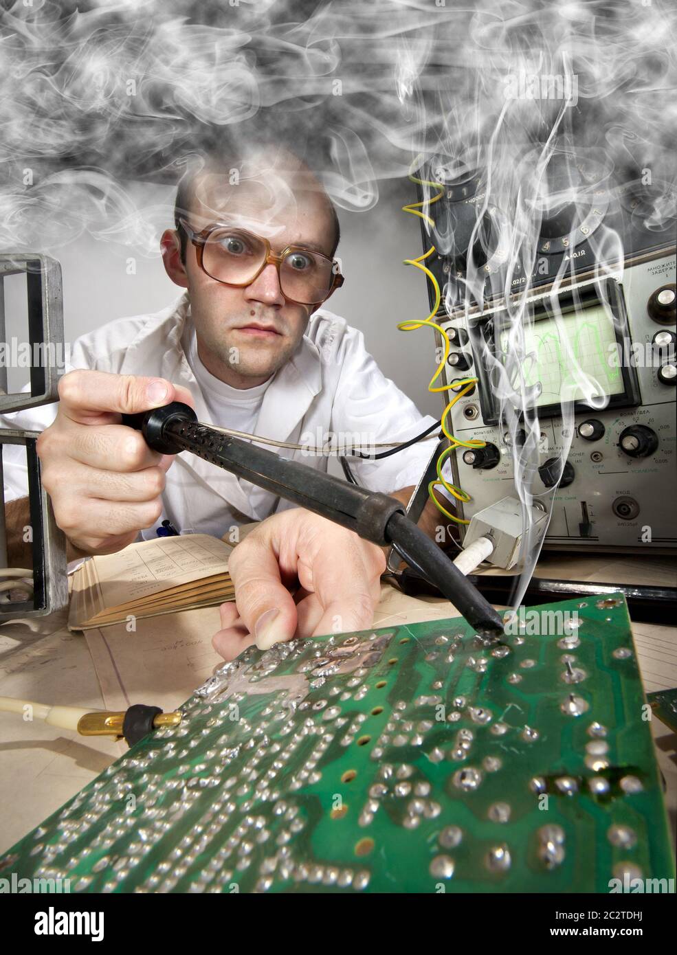 Funny nerd scientist soldering at vintage technological laboratory ...