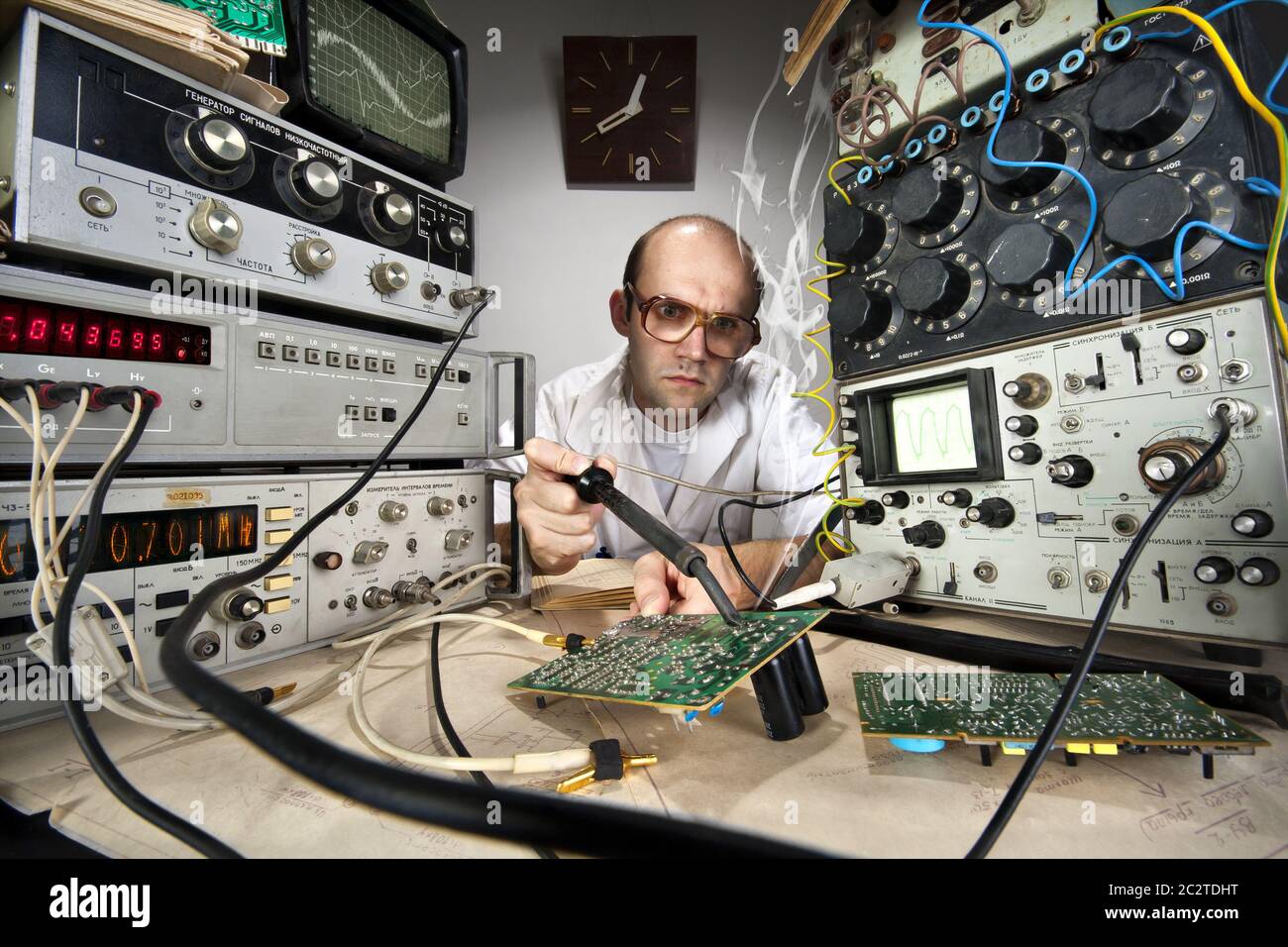 Funny nerd scientist soldering at vintage technological laboratory ...