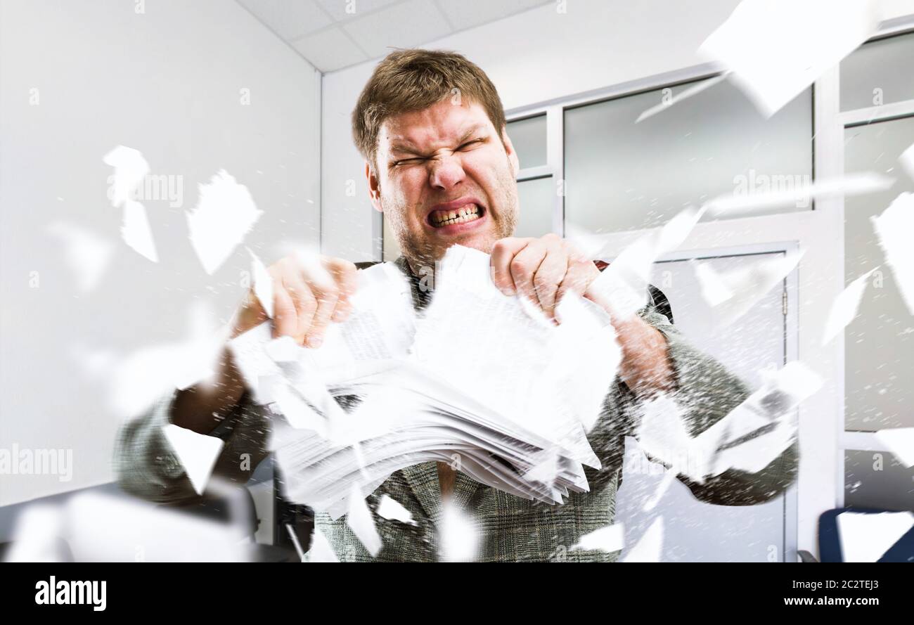 Angry businessman tearing stacks of paper in office. Mad businessperson ...