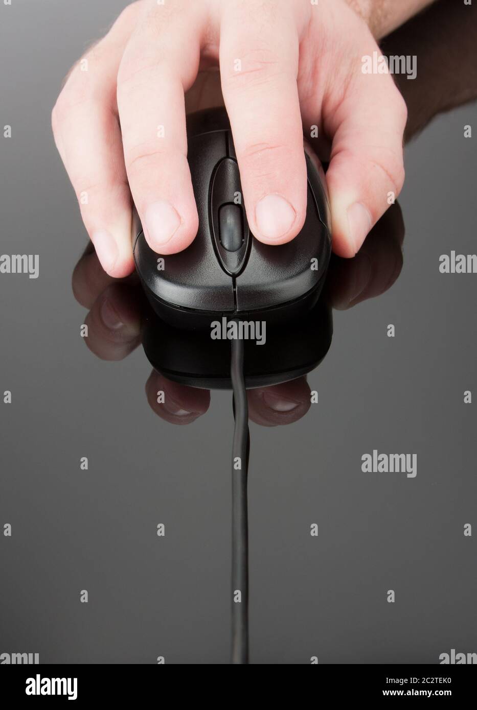 Hand holding computer mouse on reflective grey surface Stock Photo - Alamy