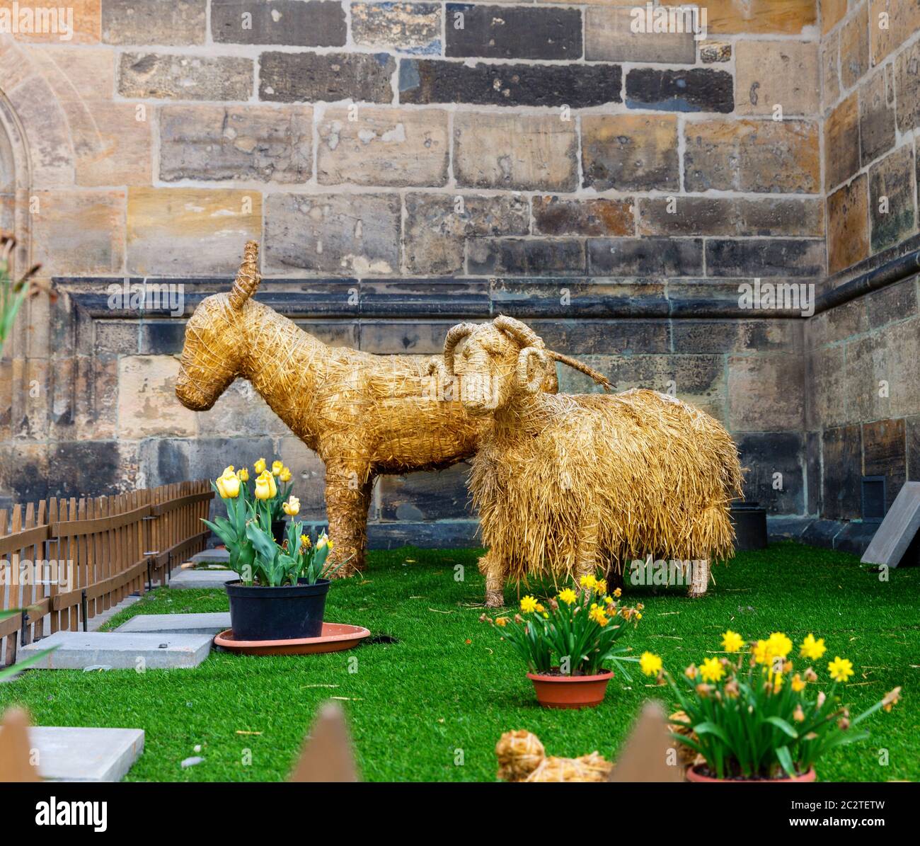 Stuffed animals from hay on lawn, old European town. Summer tourism and ...