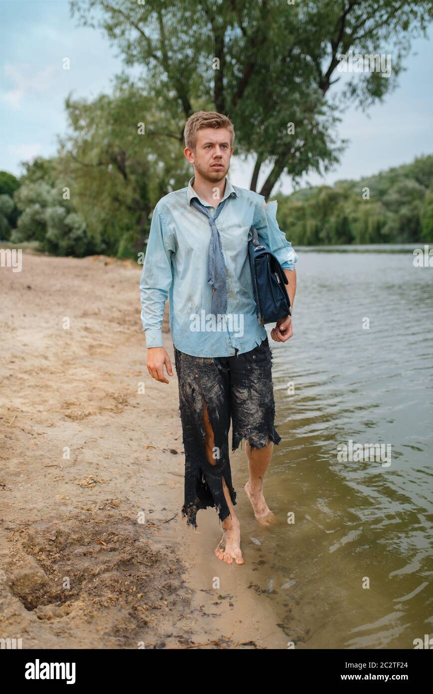Businessman in torn suit walking on the beach on lost island. Business ...