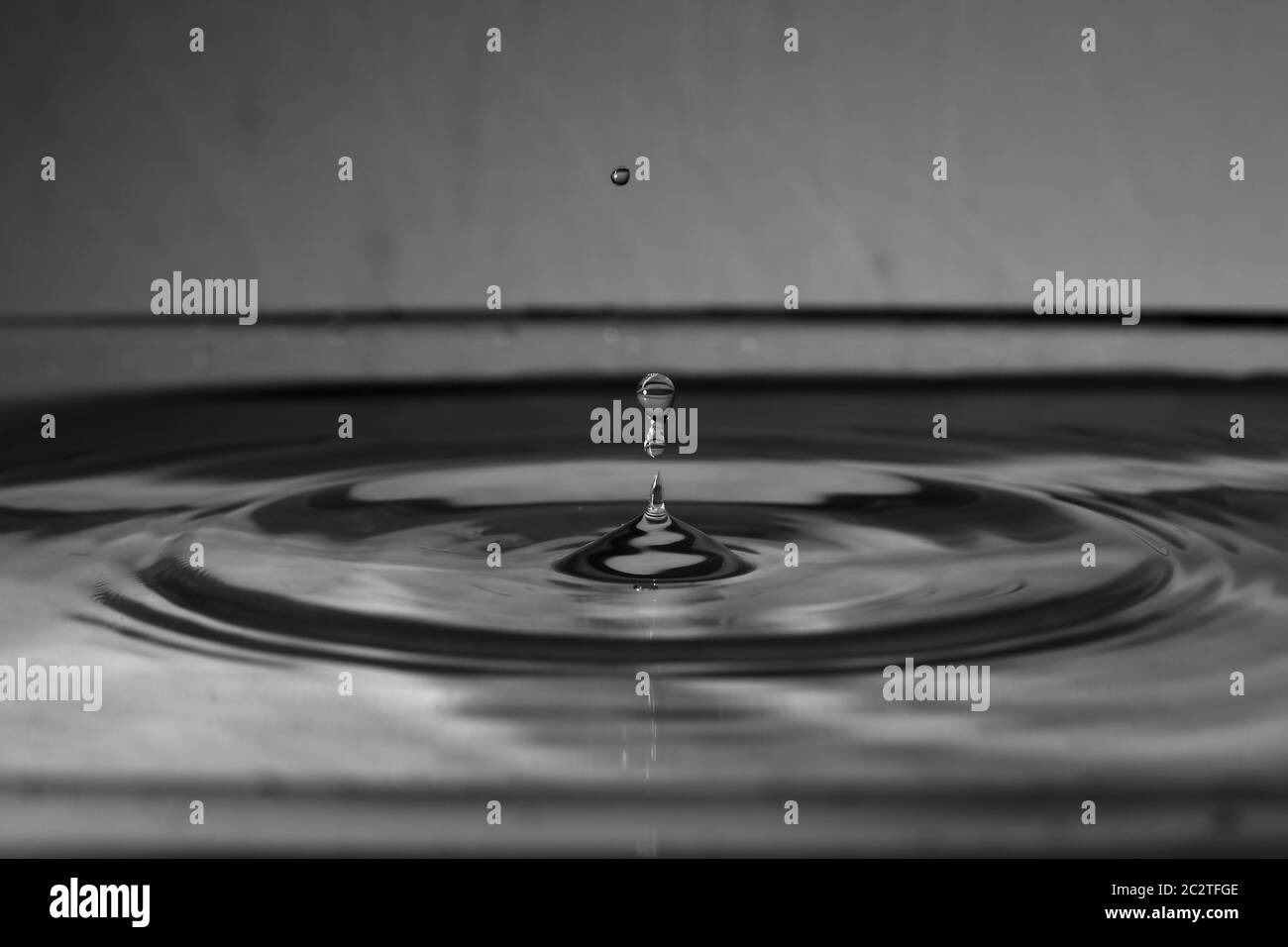 A small water drop fall on water surface Stock Photo - Alamy
