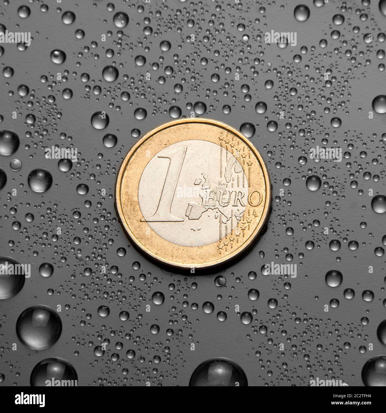 One EURO coin with water drops Stock Photo - Alamy