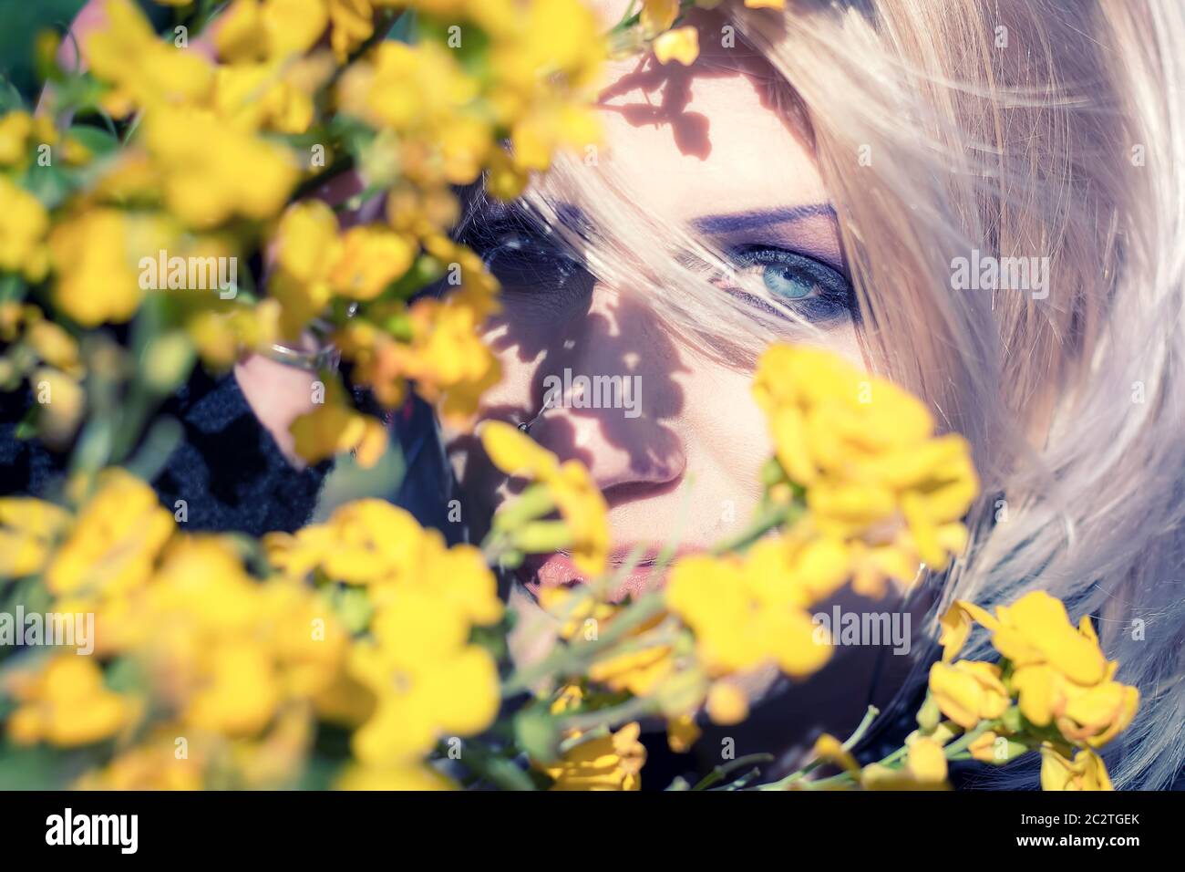 Pretty model hiding behind flowers Stock Photo - Alamy