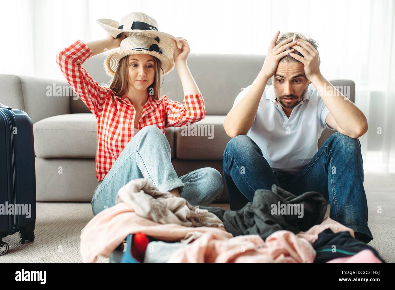 Tired couple packing their overloaded bag for vacation, overflowing ...