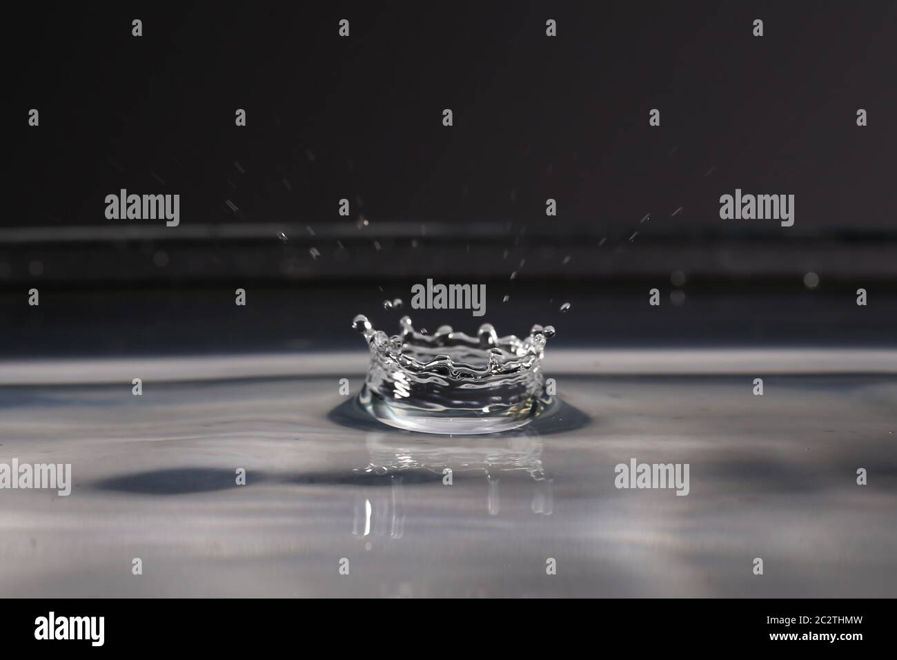 A small water drop fall on water surface Stock Photo - Alamy