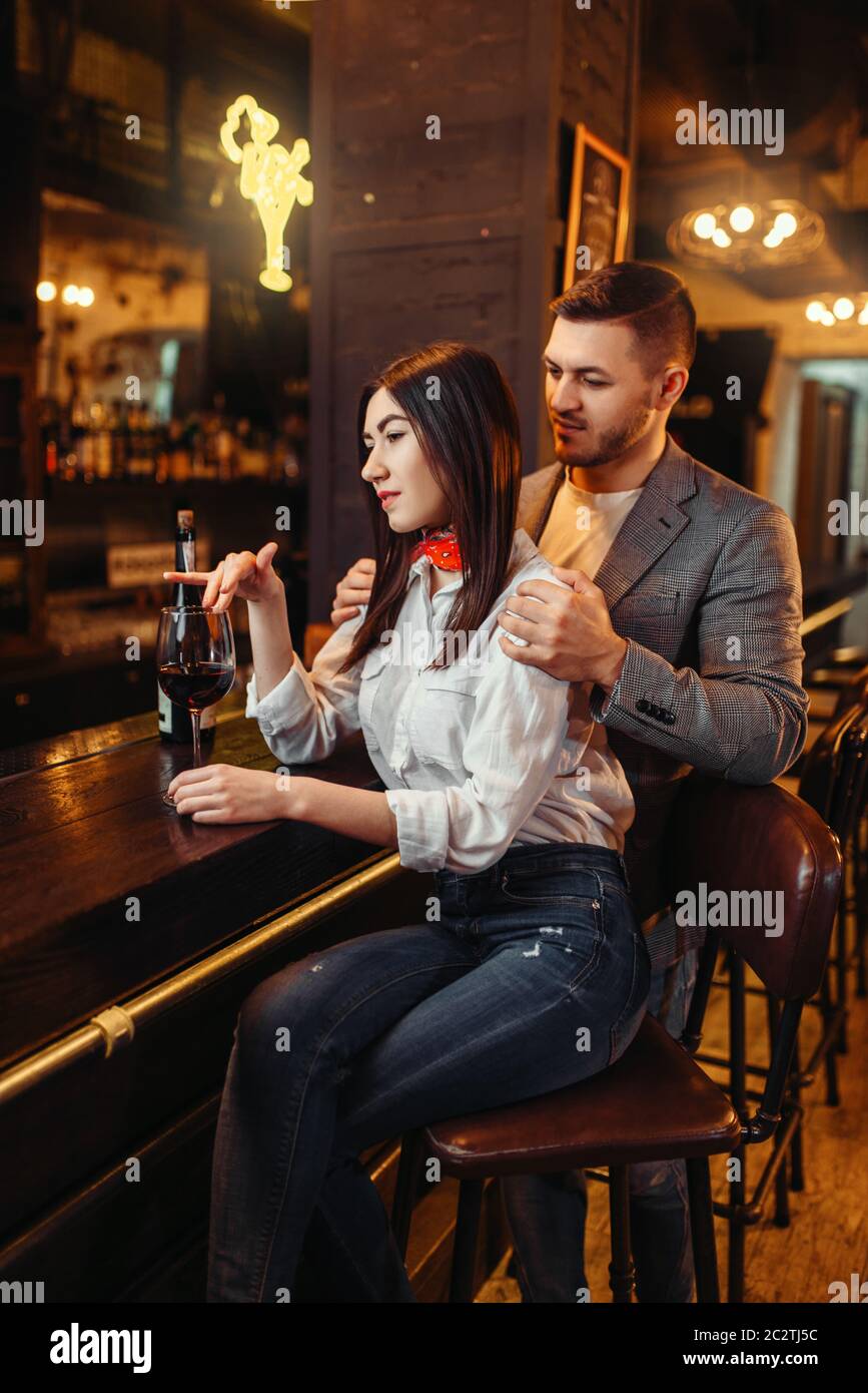 Man and woman relax, couple at wooden bar counter. Lovers leisures in ...