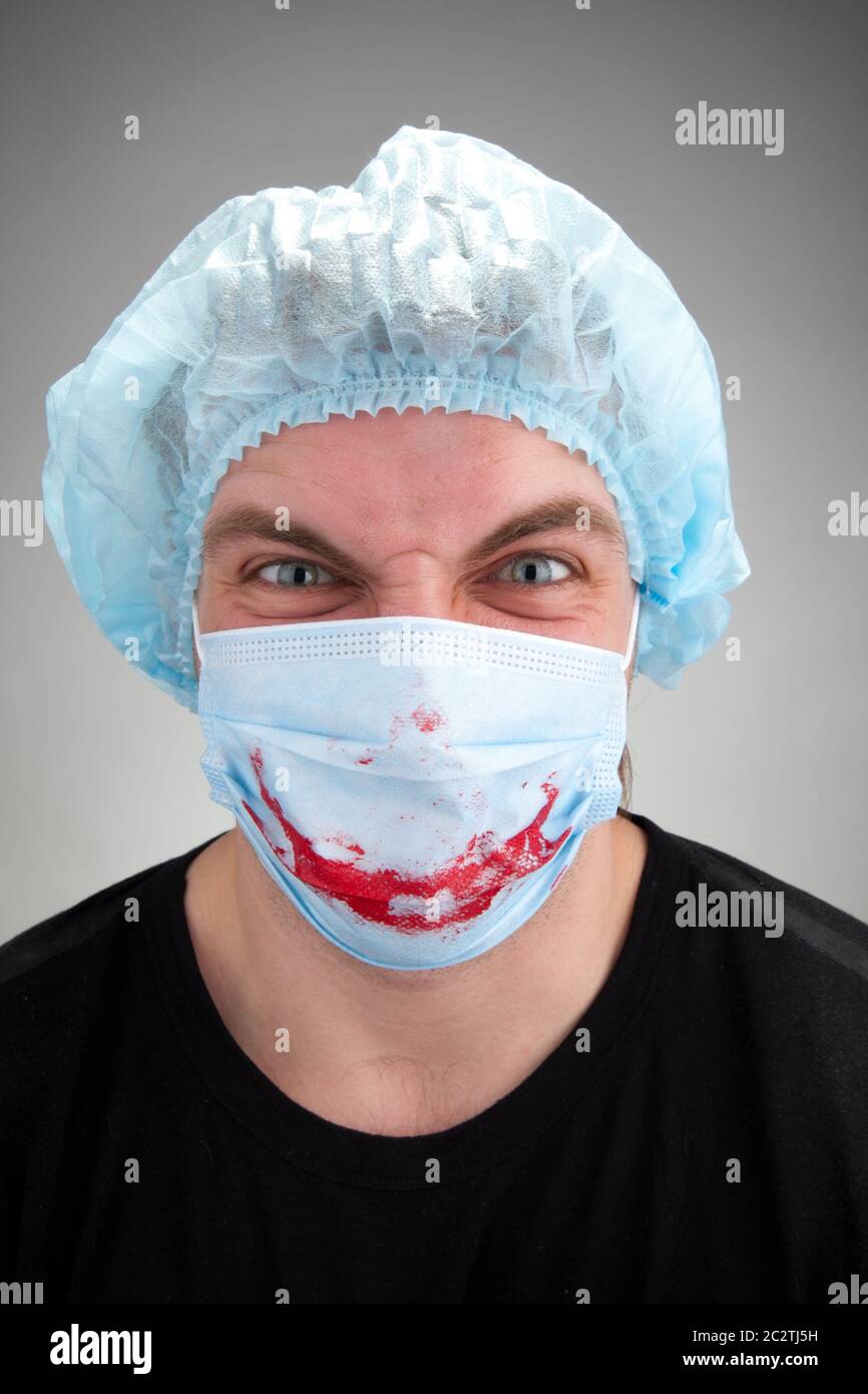 Mad mental sick surgeon with blood smile on mask Stock Photo - Alamy