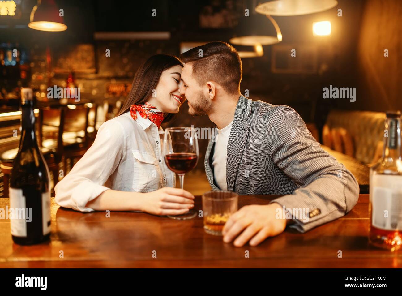 Romantic evening in bar, love couple kissing at wooden counter. Lovers ...