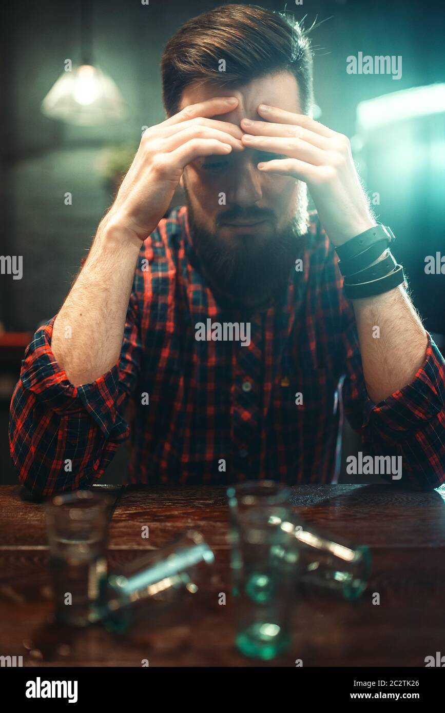 Sad man sitting at the bar counter, alcohol addiction. Male person in ...