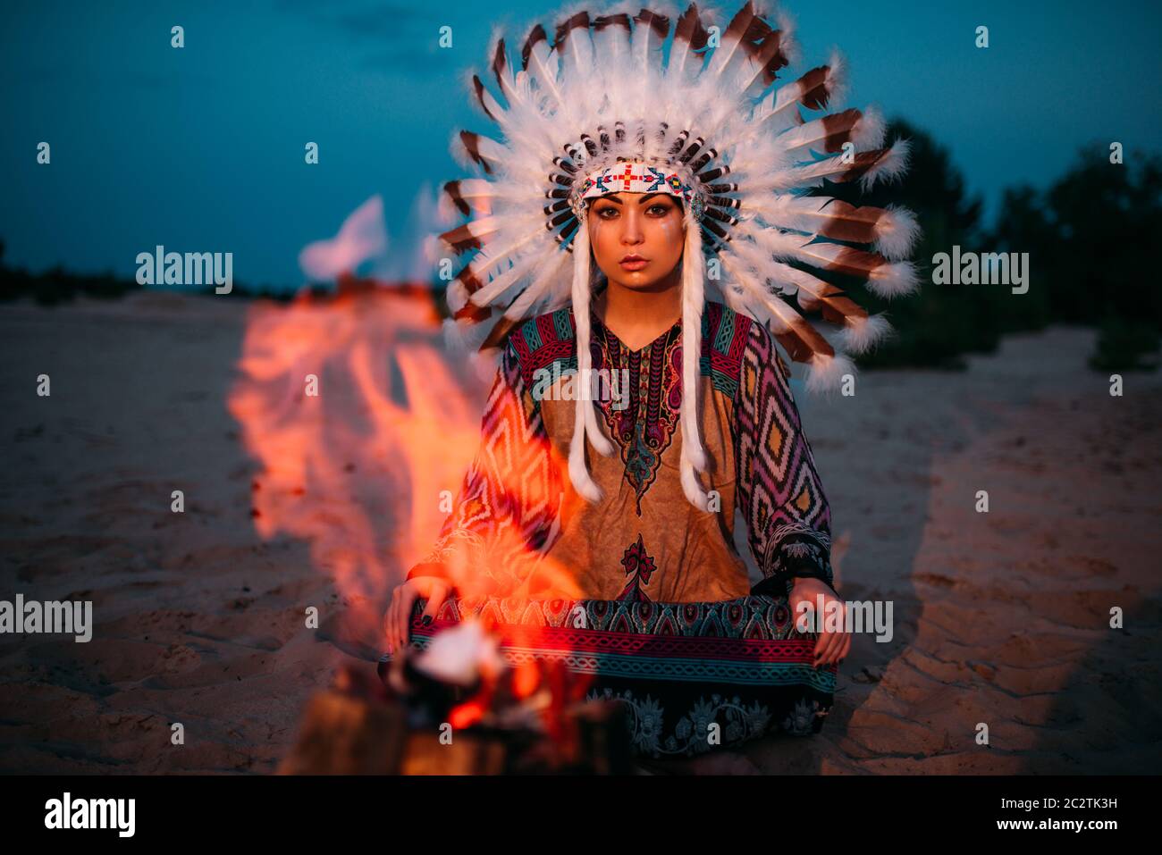 American Indian girl against bonfire in the night, female shaman ...
