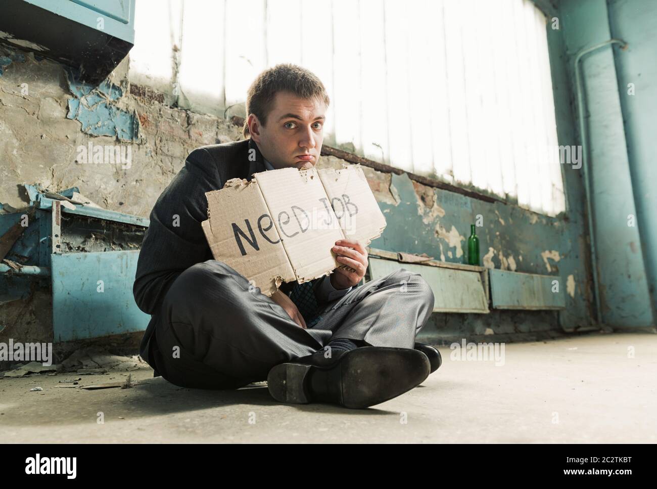 Poor businessman holding sign asking for new job Stock Photo - Alamy