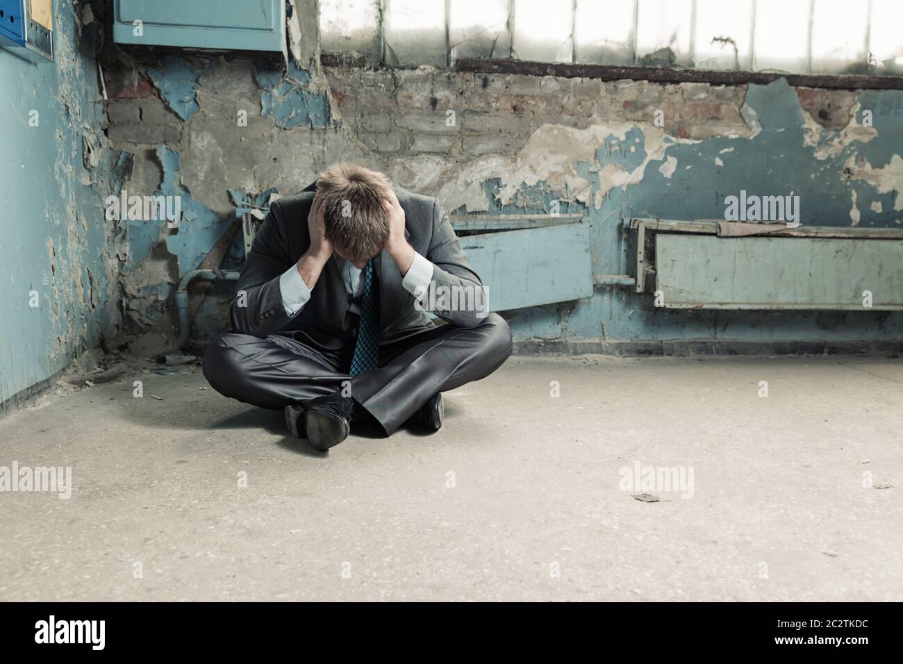 Poor homeless businessman sitting on old cellar Stock Photo - Alamy