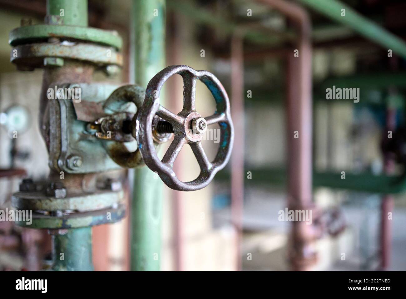 Industrial pipeline flanges hand wheel and valve close up, blur ...