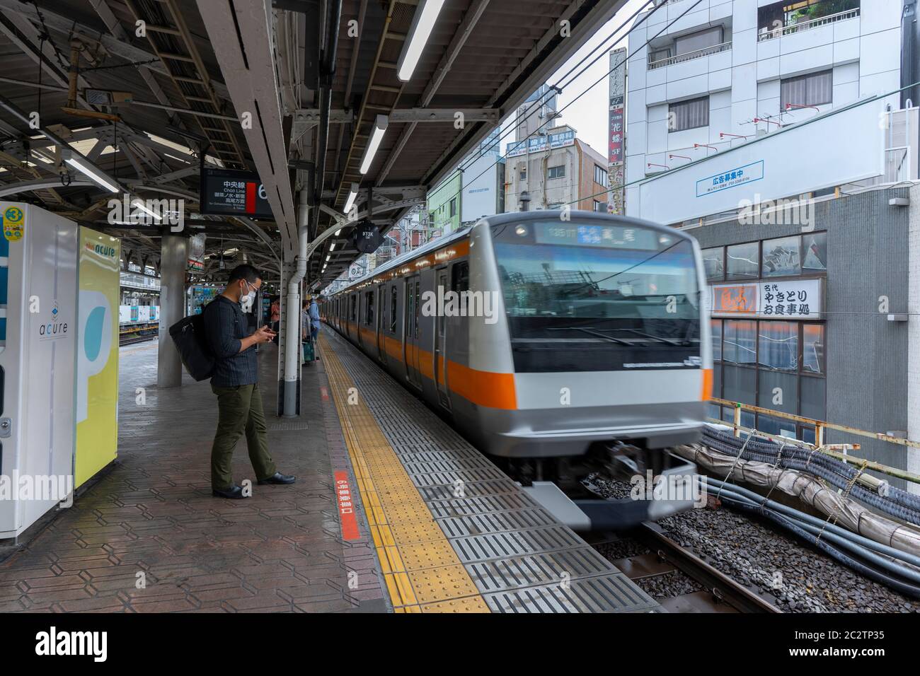 Kanda, Japan- June 14, 2020: A man waits for the train at the Kanda ...