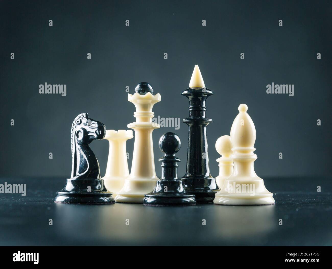 Chess figures on the table over black Stock Photo - Alamy