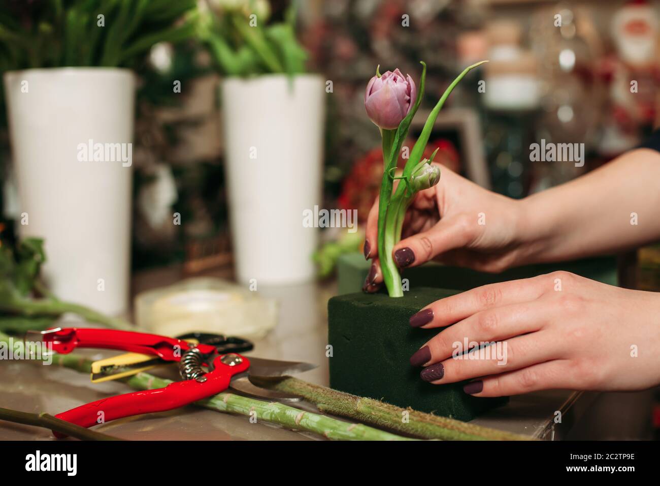Female florist working with flowers in workshop. Decorative bouquet ...