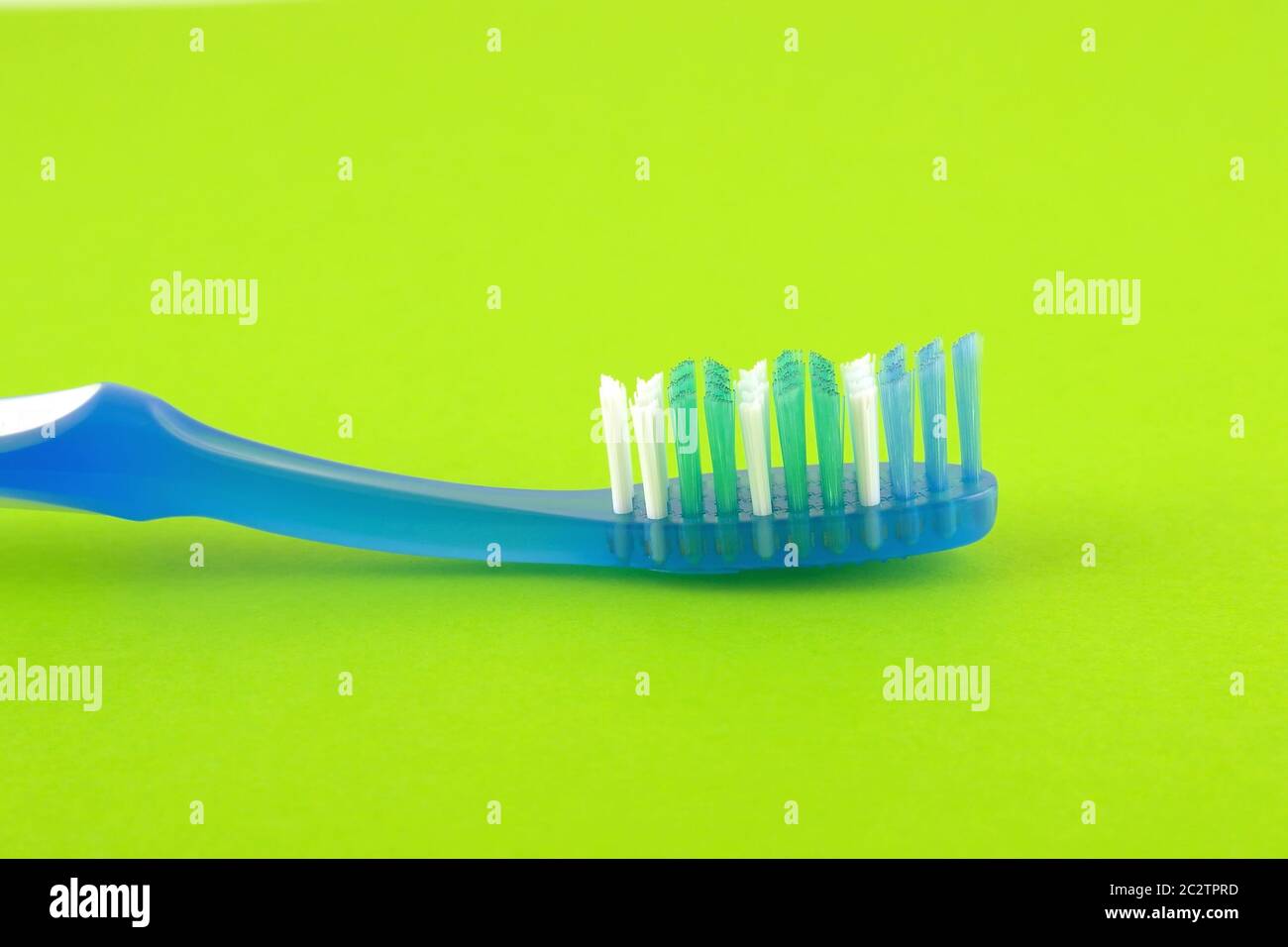 Tooth-brush over bright green Stock Photo - Alamy