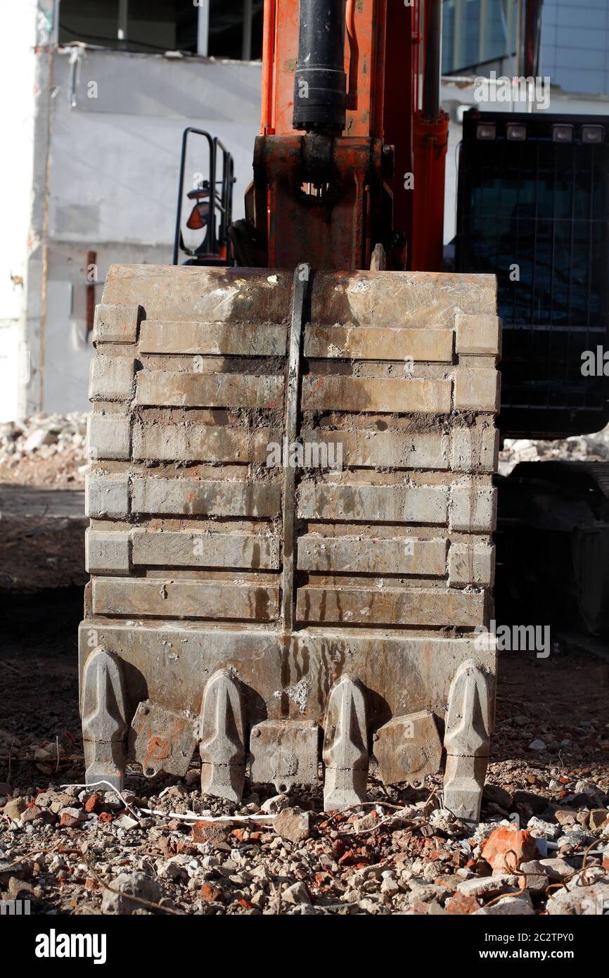 Excavator bucket, demolition excavator, rubble of a demolished house ...