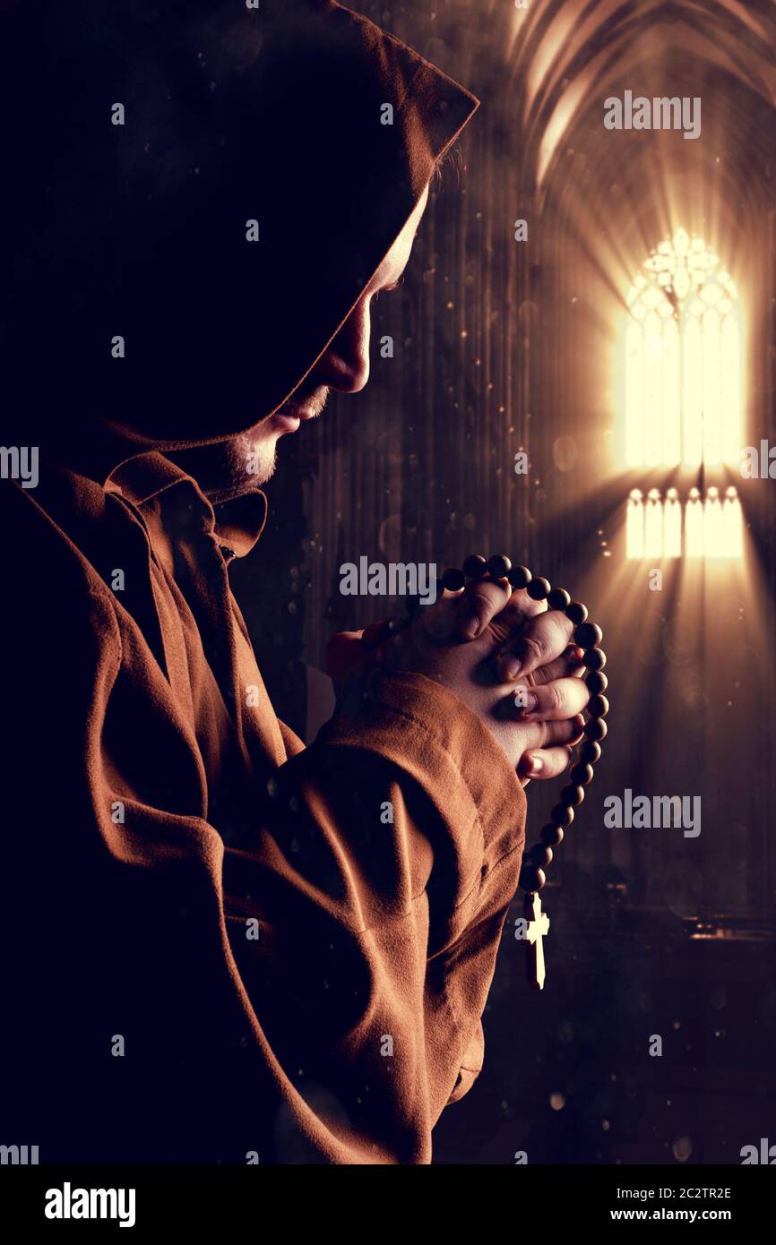 Monk in robe with two hands clasped in prayer at church Stock Photo - Alamy