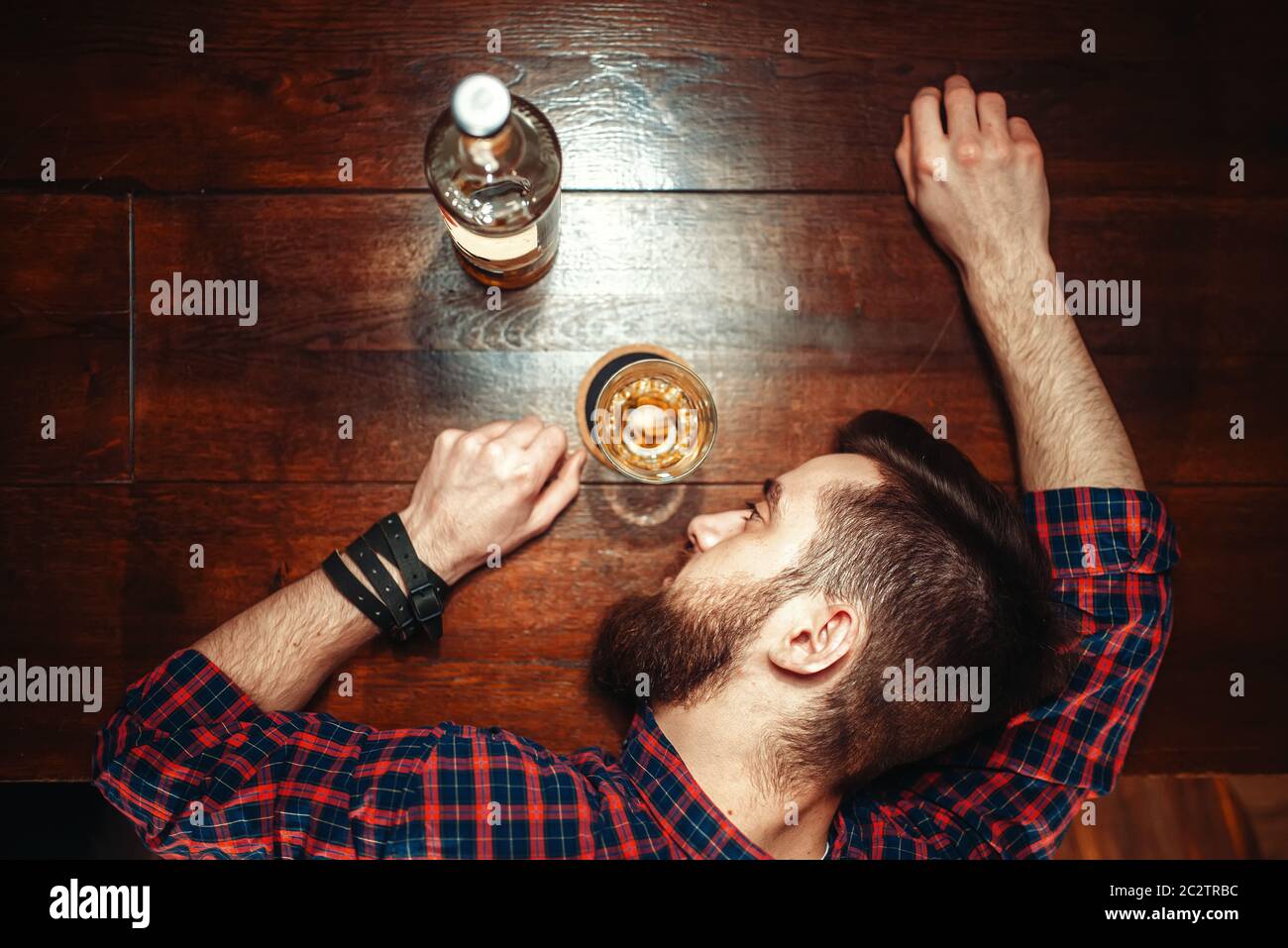Drunk man sleeps at the bar counter, top view, alcohol addiction. Male ...